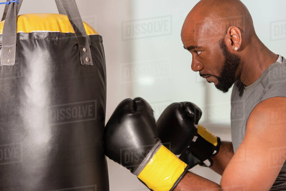 Black boxer training with punching bag - Royalty-free Stock Photo ...