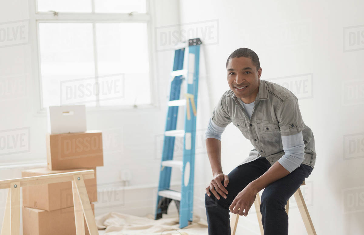 Black man sitting in room under renovation - Royalty-free Stock Photo ...