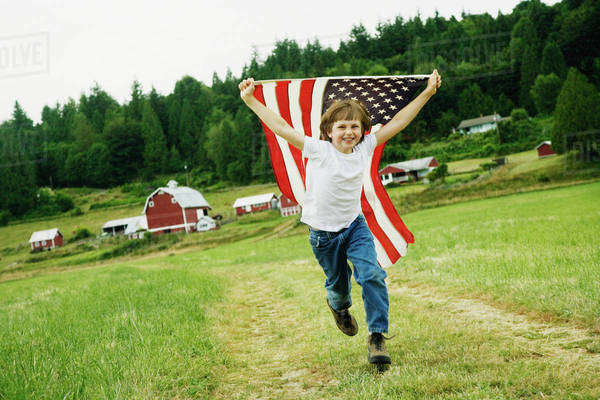 Boy running with American flag at farm - Royalty-free Stock Photo ...