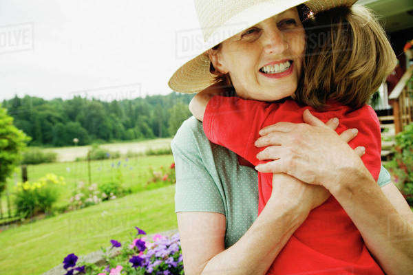 Mother hugging child outdoors - Stock Photo - Dissolve