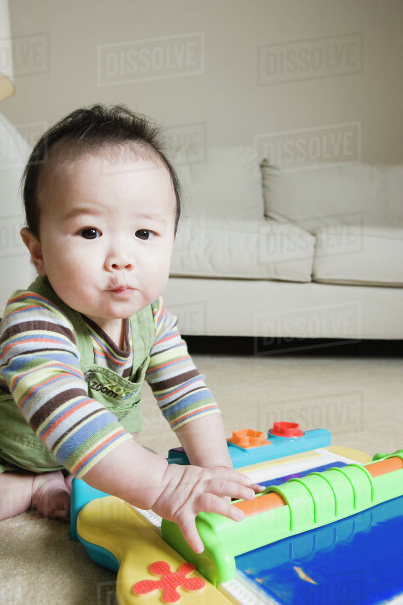 Asian baby playing on the floor - Royalty-free Stock Photo | Dissolve