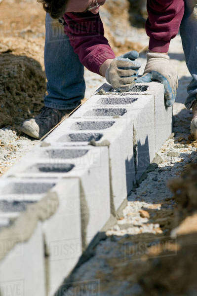 Worker filling cinder blocks with mortar - Royalty-free Stock Photo ...