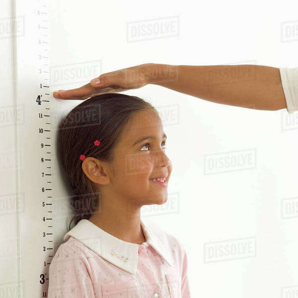 Woman measuring girl's height - Royalty-free Stock Photo | Dissolve