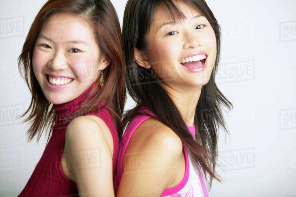 Portrait of sisters back to back - Royalty-free Stock Photo | Dissolve