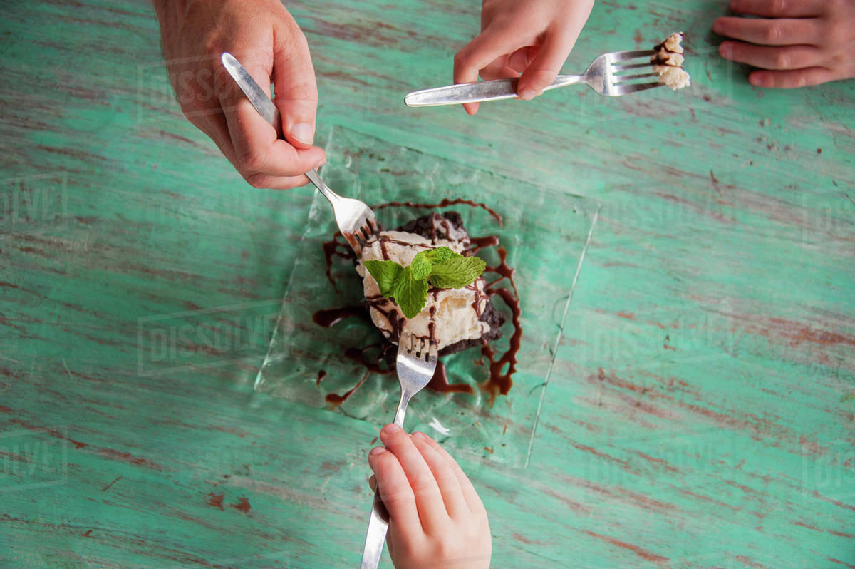 High angle view of hands reaching for food on plate - Royalty-free ...