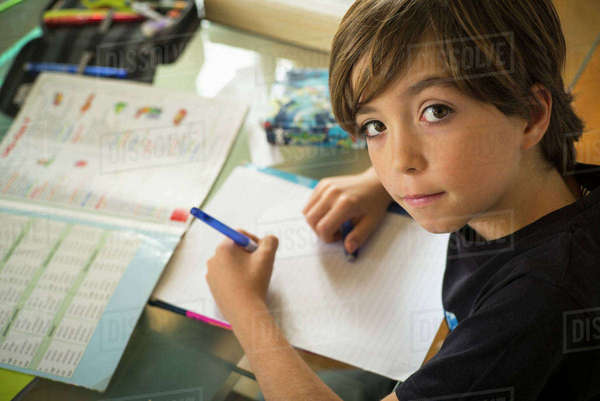 Caucasian boy doing homework - Stock Photo - Dissolve
