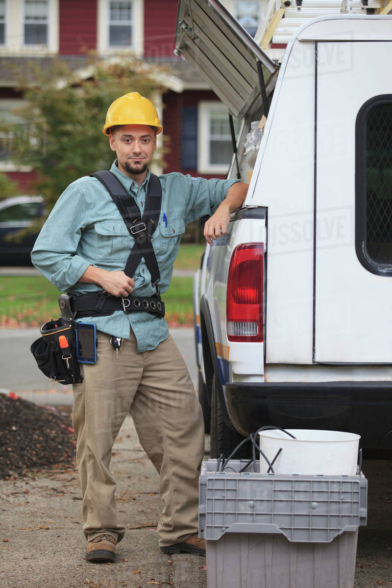 Caucasian worker smiling at truck - Royalty-free Stock Photo | Dissolve