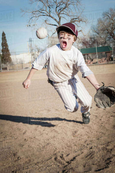 Caucasian boy catching baseball on field - Stock Photo - Dissolve