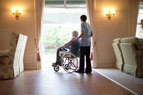 Nurse pushing patient in wheelchair - Royalty-free Stock Photo | Dissolve