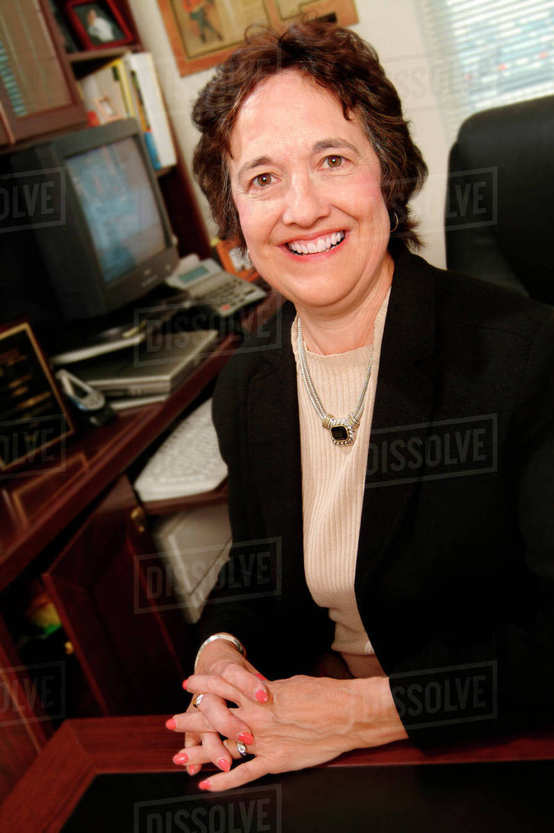 Businesswoman smiling at desk - Royalty-free Stock Photo | Dissolve