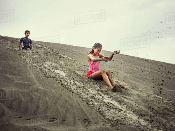 Children sliding on sand dune - Royalty-free Stock Photo | Dissolve