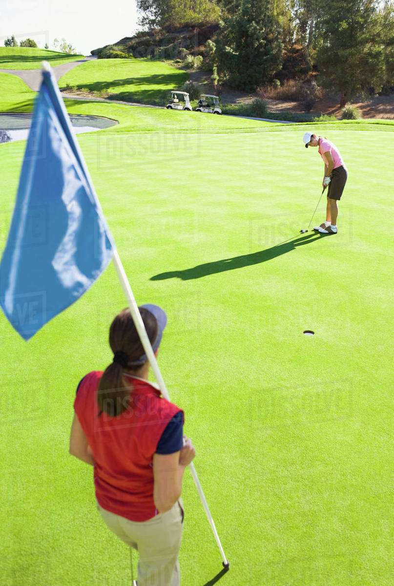 Women putting on green at golf course - Royalty-free Stock Photo | Dissolve