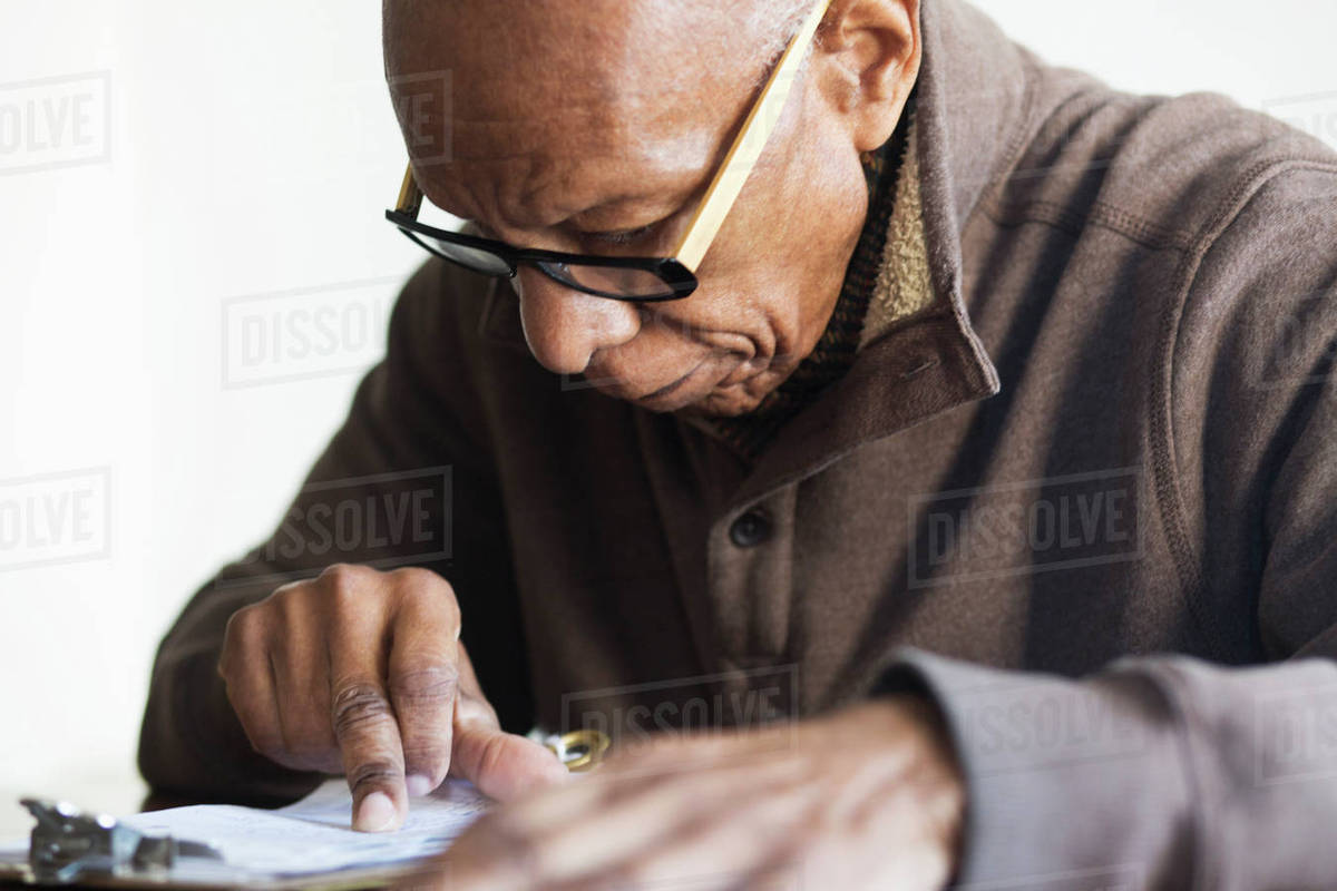 Older Black man reading notes - Royalty-free Stock Photo | Dissolve