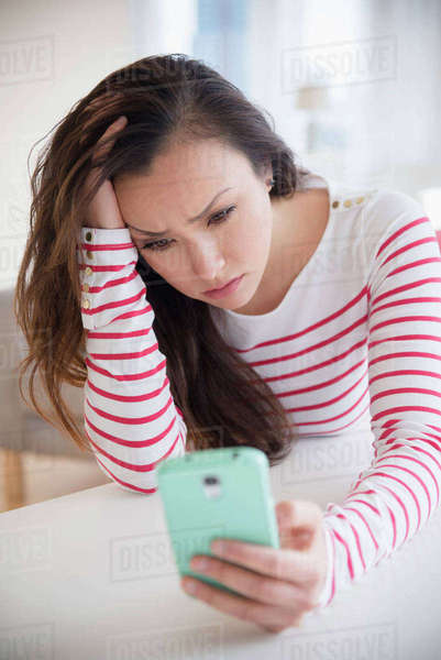 Stressed woman using cell phone - Royalty-free Stock Photo | Dissolve