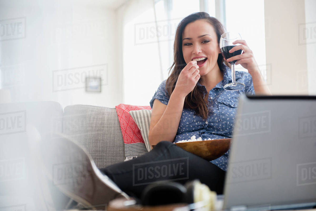 Woman watching movie on laptop in living room - Royalty-free Stock ...