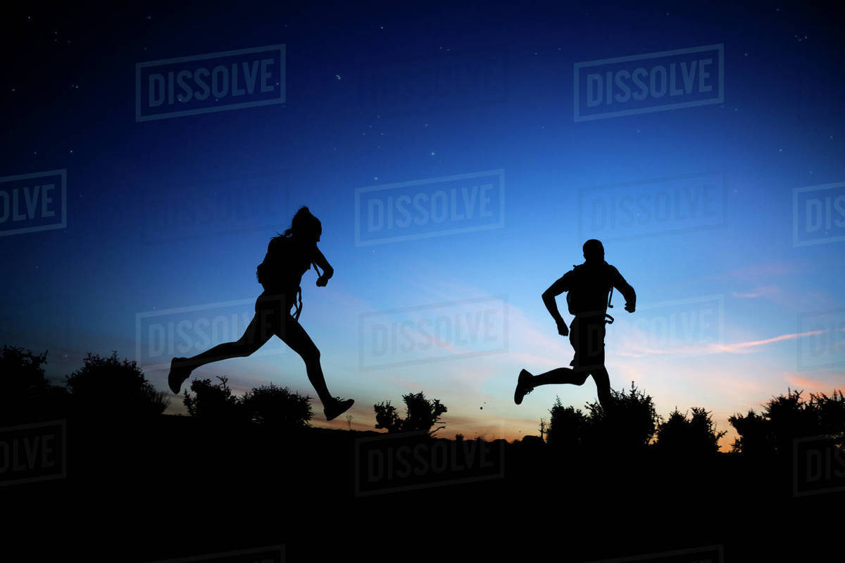 Silhouette of Caucasian couple running at dawn - Royalty-free Stock ...