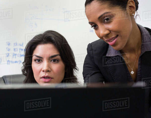 Businesswomen using computer in office - Stock Photo - Dissolve