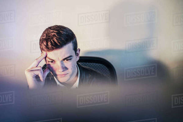 Caucasian teenage boy using computer - Royalty-free Stock Photo | Dissolve