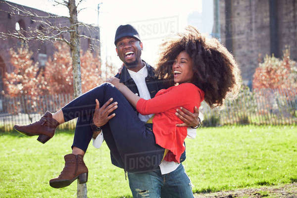 Man carrying woman and laughing - Royalty-free Stock Photo | Dissolve