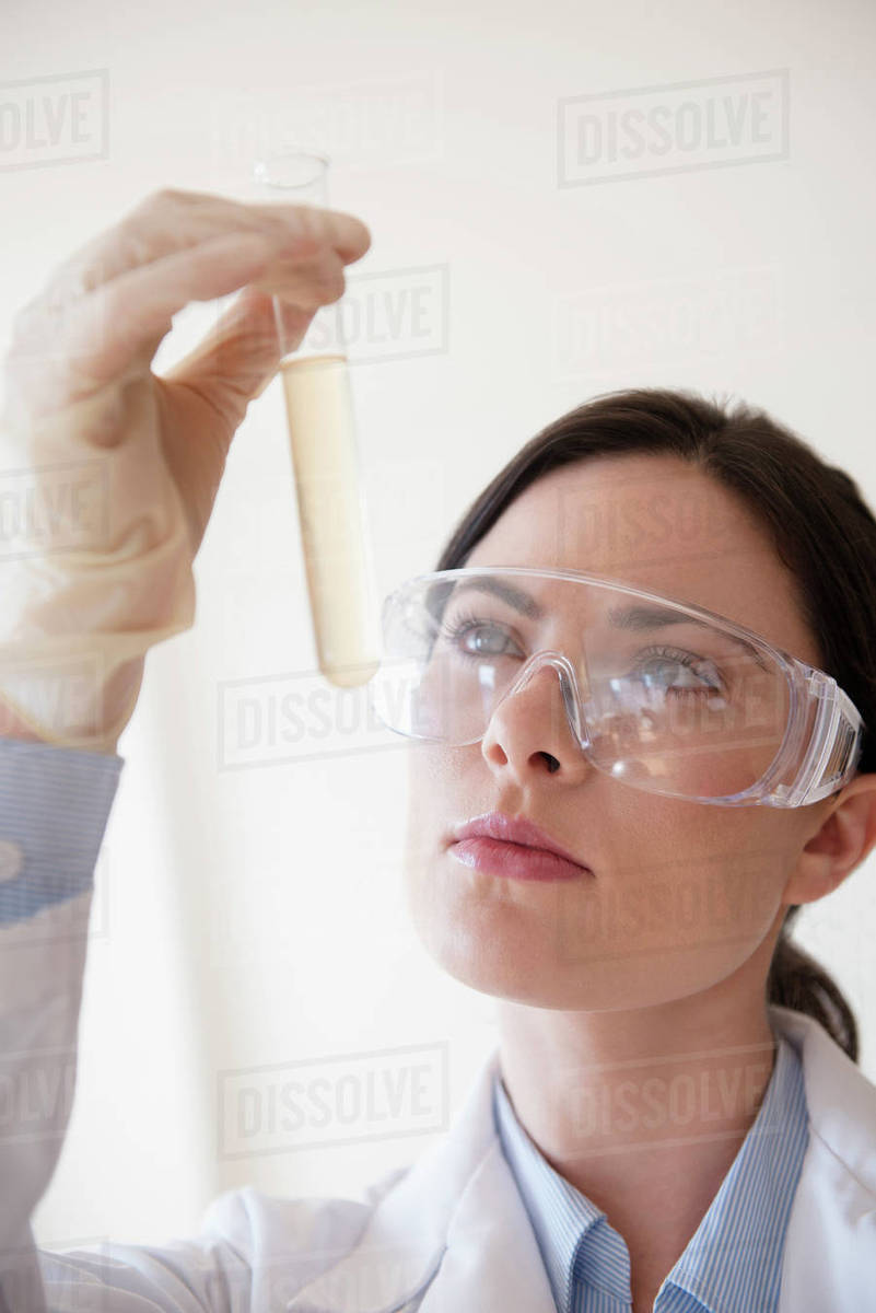 Caucasian scientist holding vial - Stock Photo - Dissolve