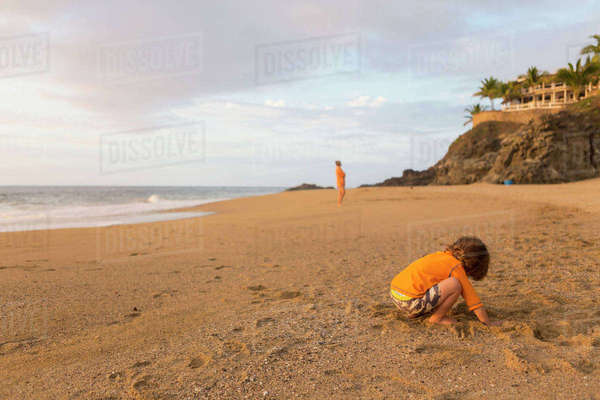 Caucasian boy digging in sand on beach - Royalty-free Stock Photo ...