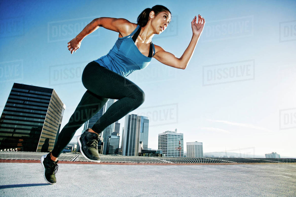 Mixed Race woman running on urban rooftop - Royalty-free Stock Photo ...
