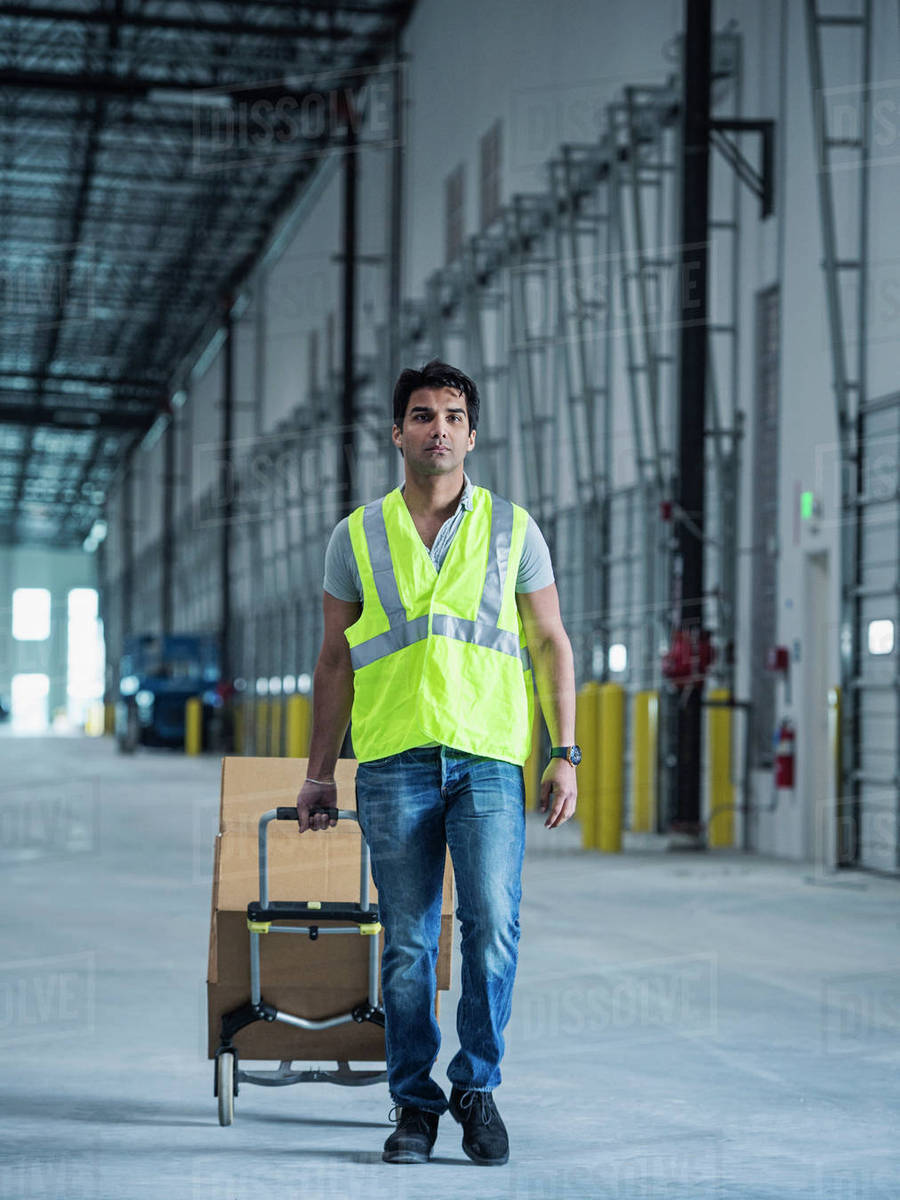 Indian worker pulling box on hand truck in warehouse - Stock Photo ...