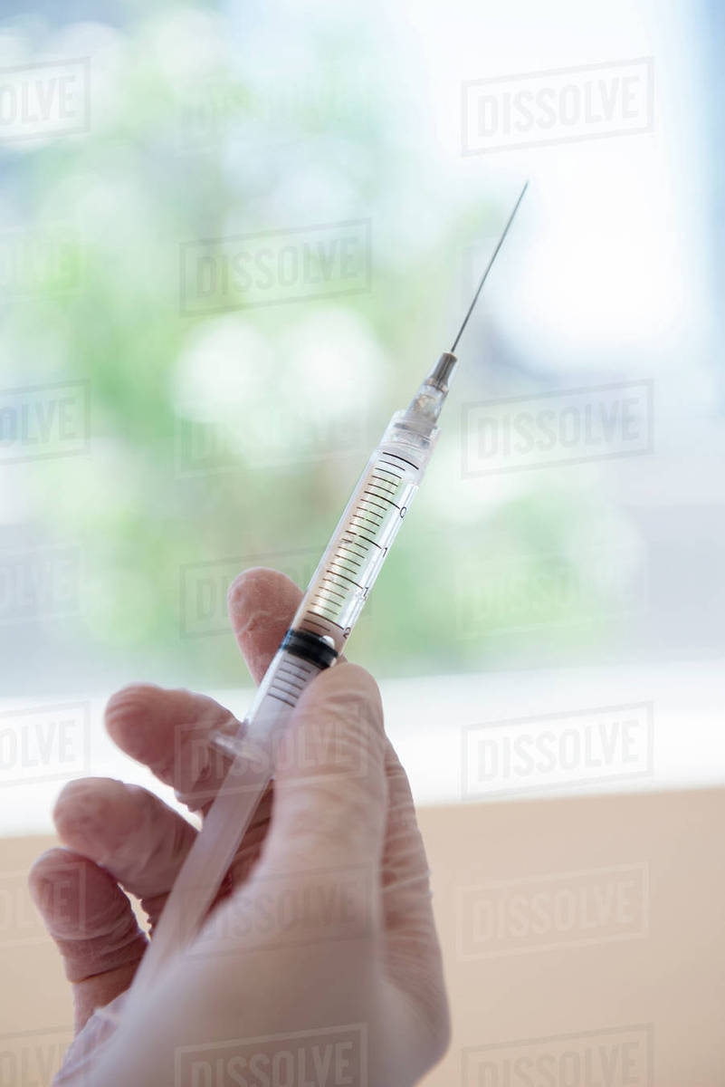 Hand holding syringe - Royalty-free Stock Photo | Dissolve