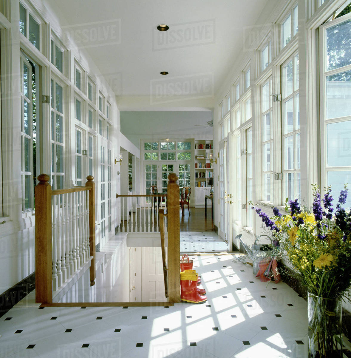Hallway with windows and gardening equipment by staircase - Royalty ...