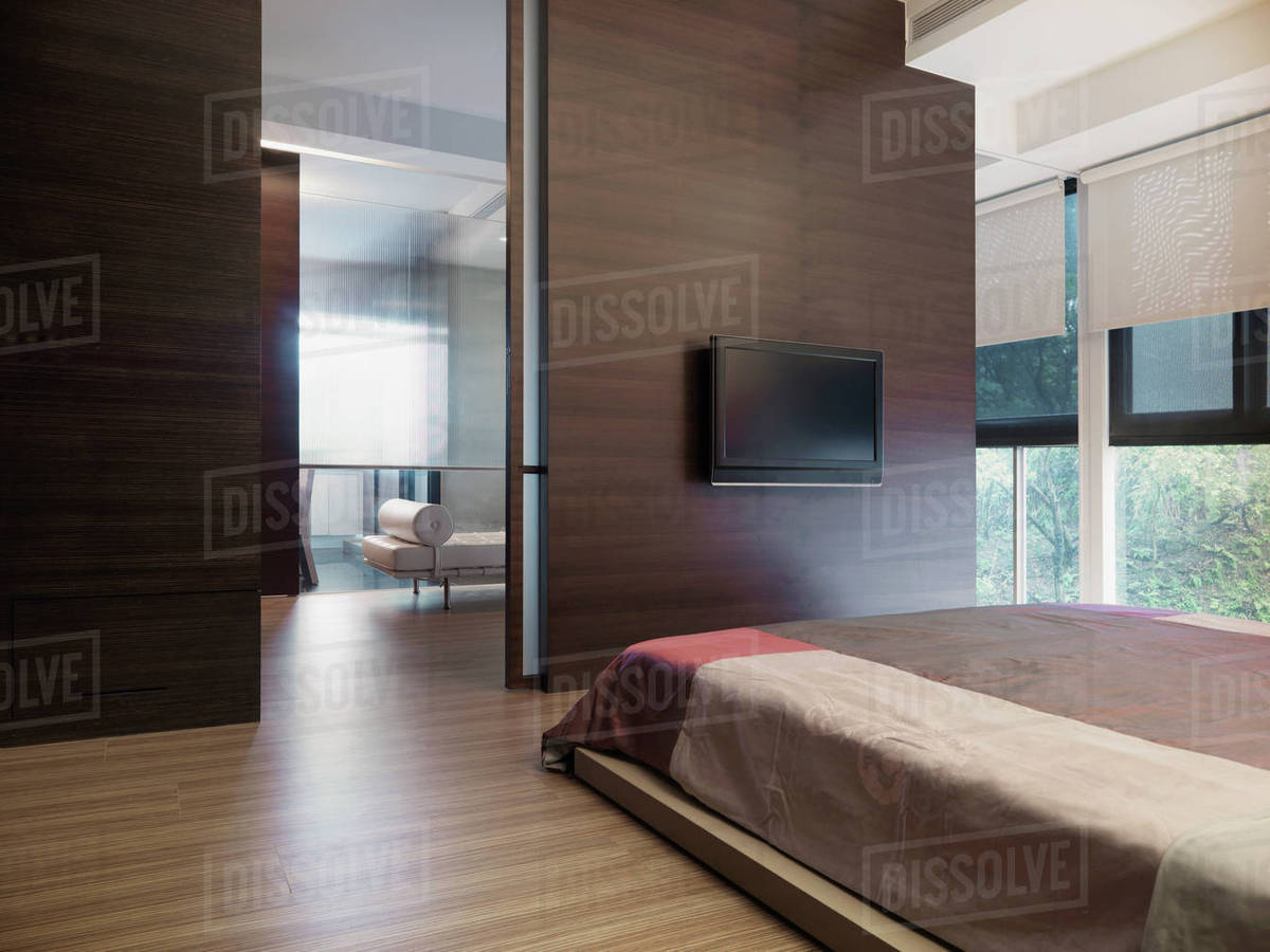 Simple modern bedroom with flat screen television - Stock Photo - Dissolve