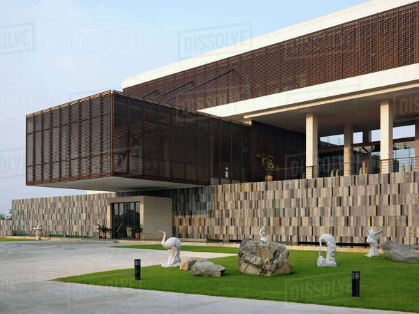 Crane statues on lawn outside modern building - Stock Photo - Dissolve