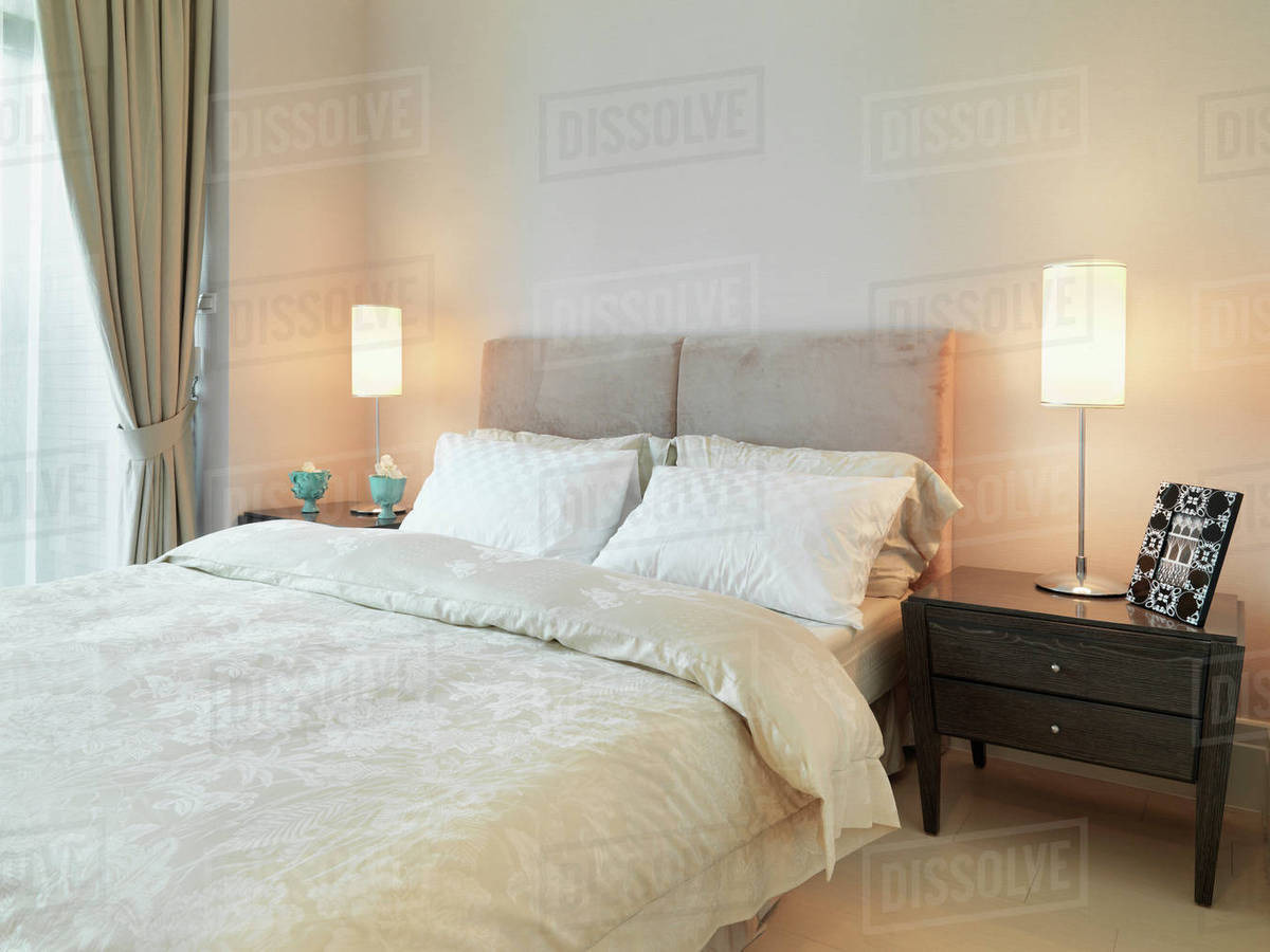 Light colored bed in modern bedroom - Royalty-free Stock Photo | Dissolve