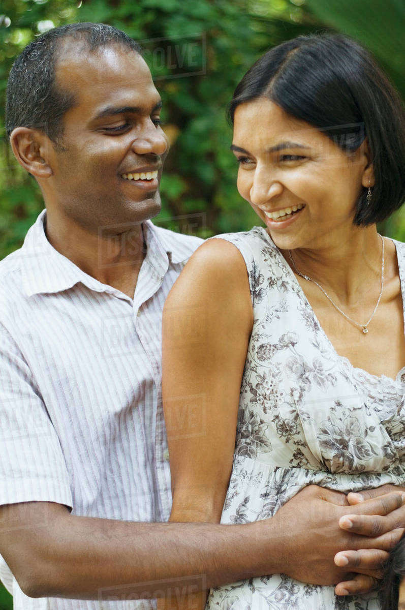 Indian couple hugging outdoors - Stock Photo - Dissolve