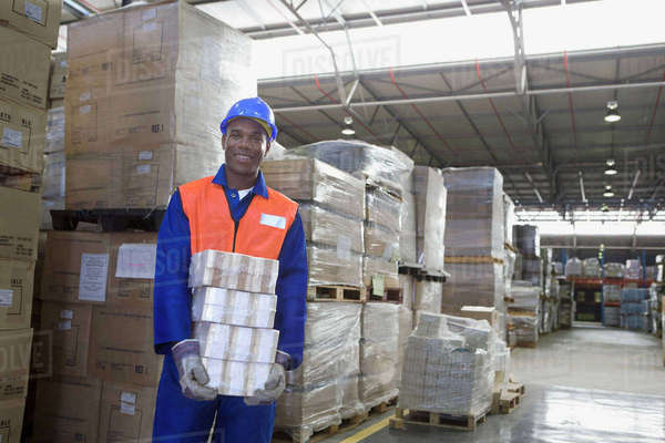 African worker carrying package in warehouse - Royalty-free Stock Photo ...