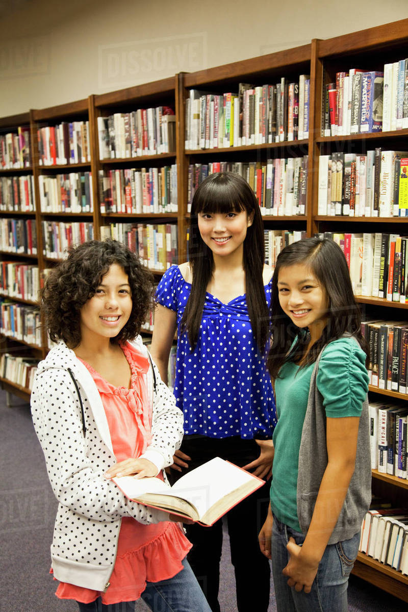 Girls standing in library - Royalty-free Stock Photo | Dissolve