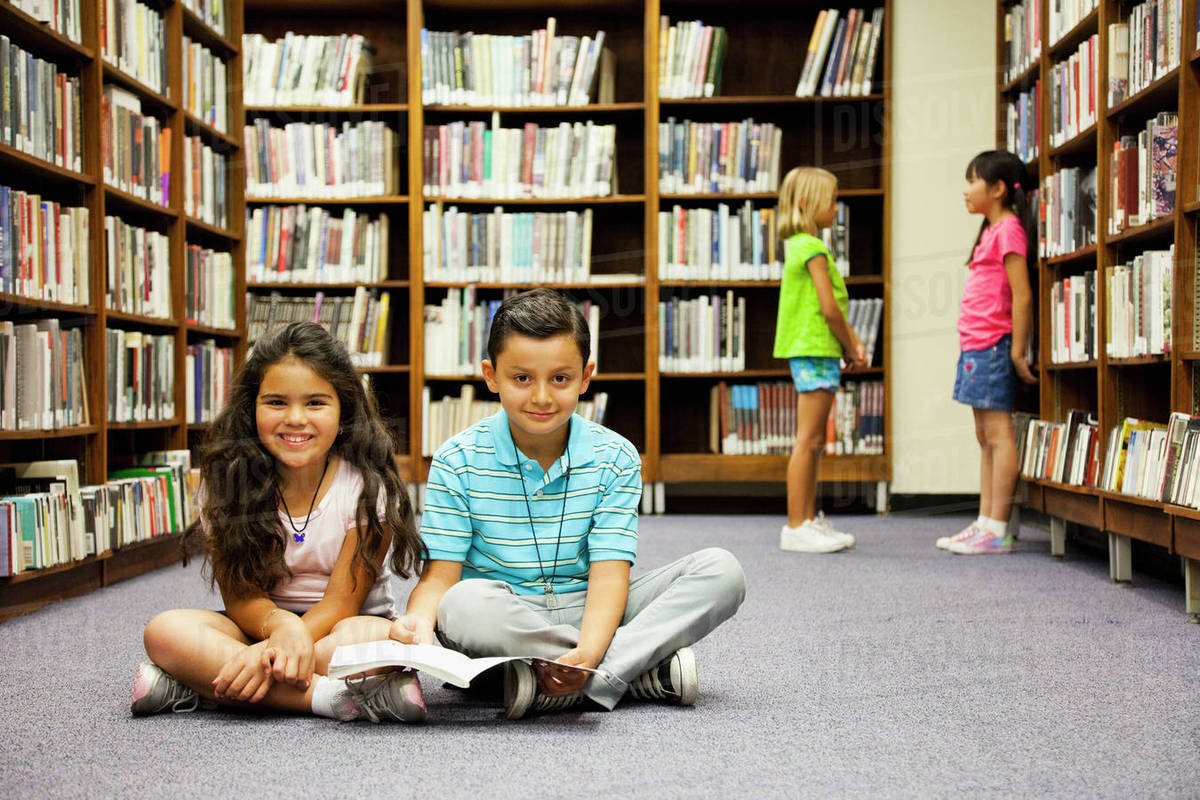 Children sitting on library floor - Stock Photo - Dissolve