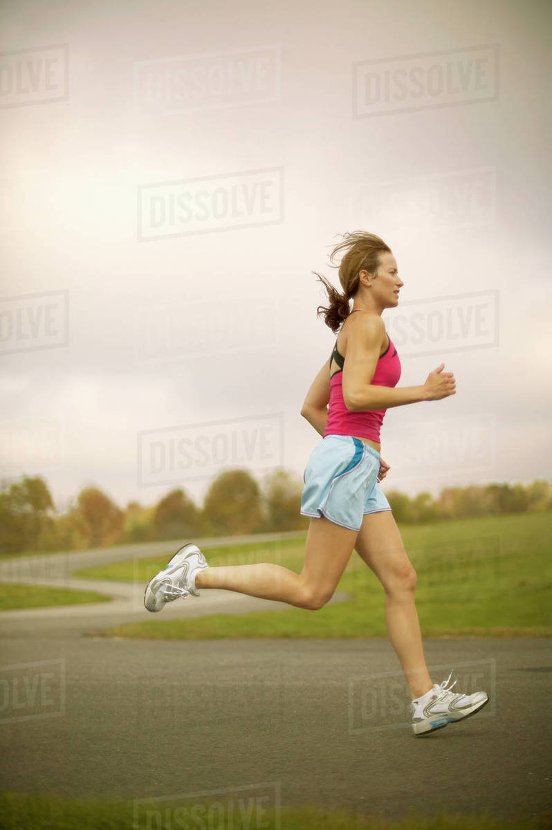 Woman jogging on path - Royalty-free Stock Photo | Dissolve