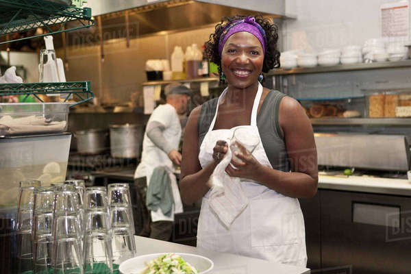 Black waitress working in restaurant kitchen - Stock Photo - Dissolve