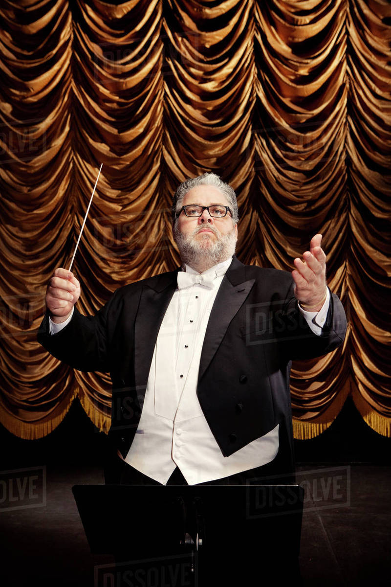 Caucasian conductor at podium - Royalty-free Stock Photo | Dissolve
