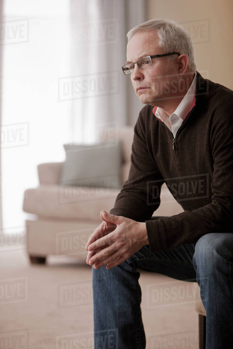 Serious Caucasian man sitting in living room - Royalty-free Stock Photo ...