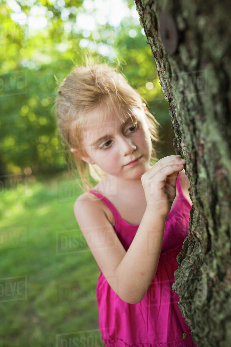 Caucasian girl looking at tree - Royalty-free Stock Photo | Dissolve