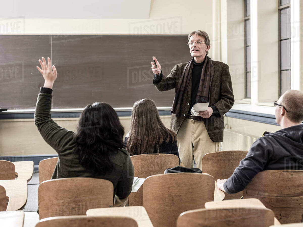 Teacher talking to students in classroom - Royalty-free Stock Photo ...