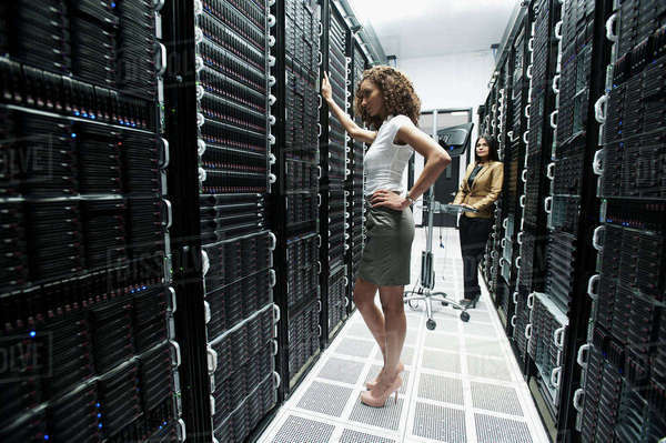 Businesswomen working in server room - Stock Photo - Dissolve