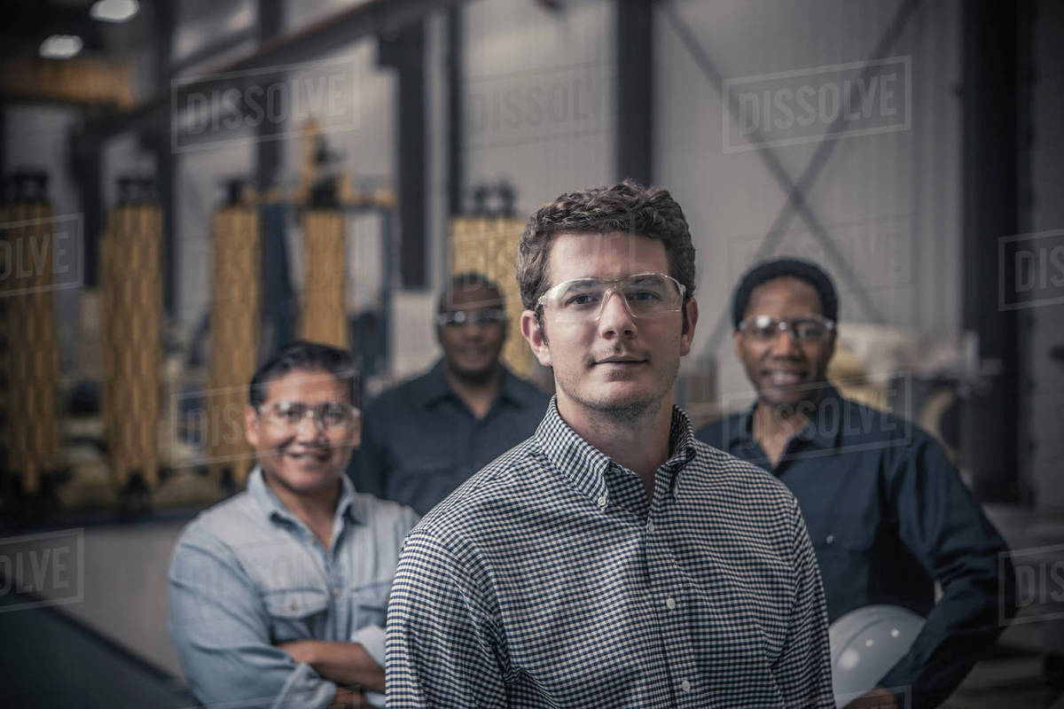 Workers standing together in factory - Stock Photo - Dissolve