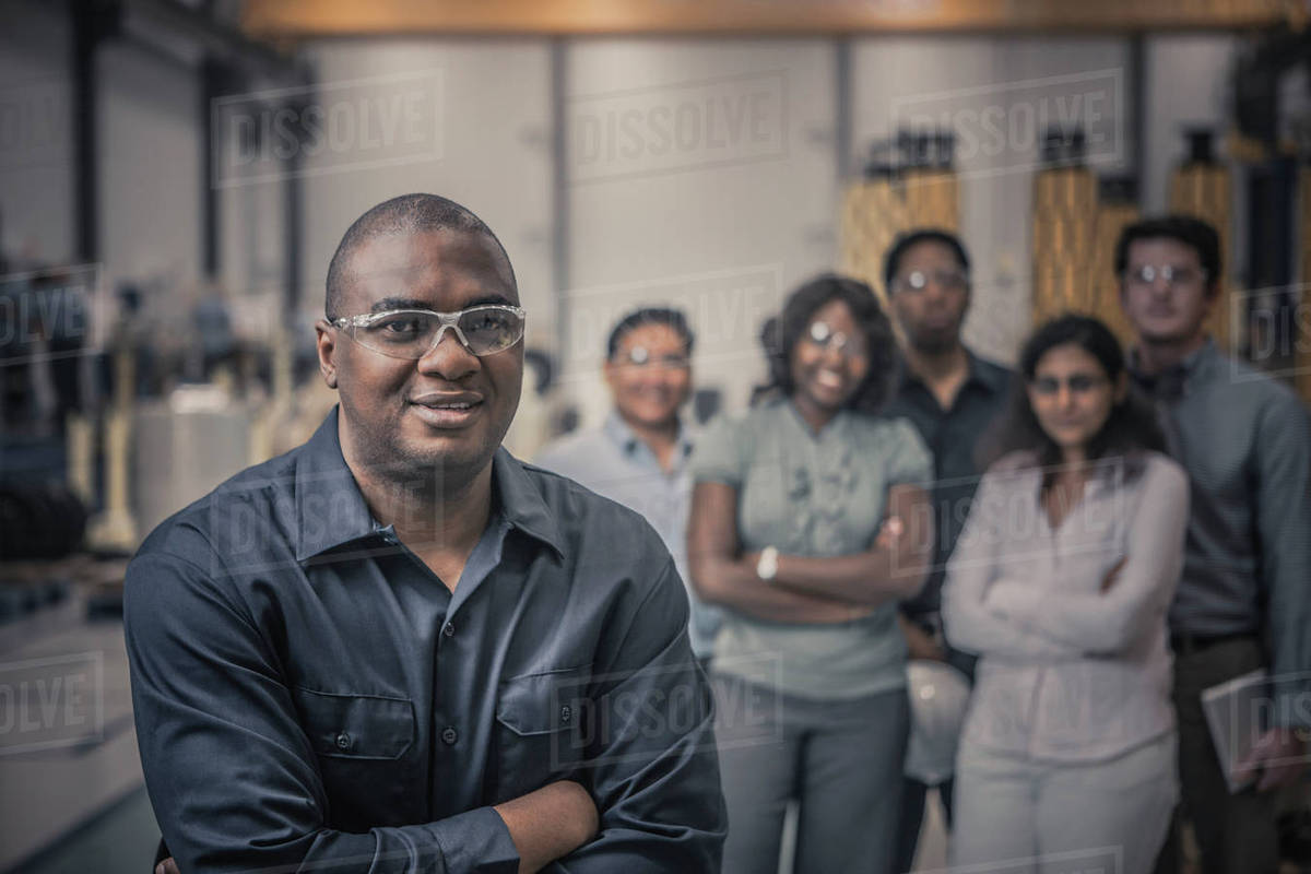 Workers standing together in factory - Royalty-free Stock Photo | Dissolve