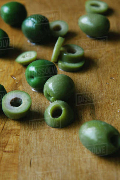 Sliced green olives on cutting board - Stock Photo - Dissolve