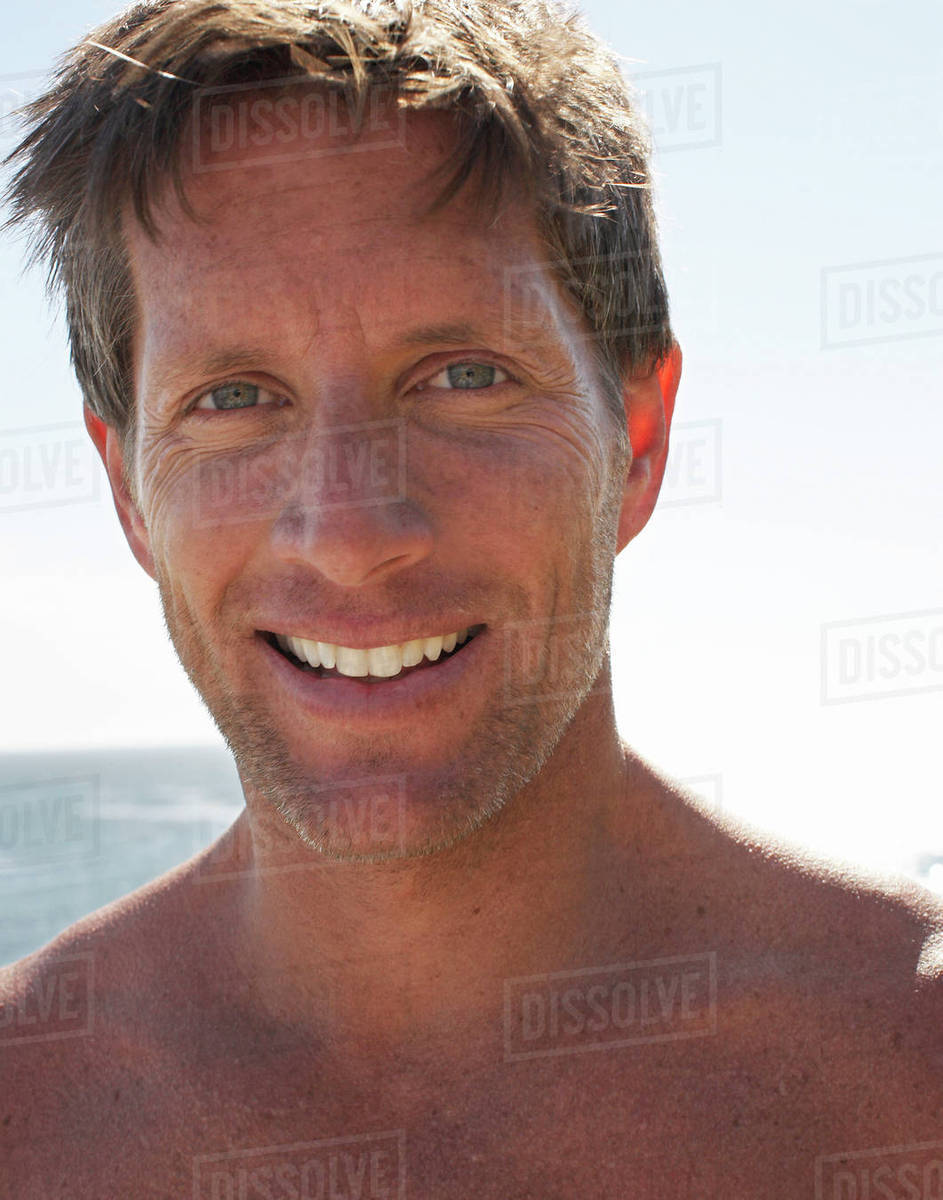 Smiling man at beach - Stock Photo - Dissolve