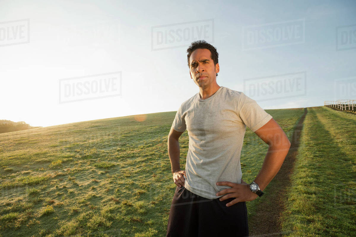 Mixed race runner standing in field - Stock Photo - Dissolve