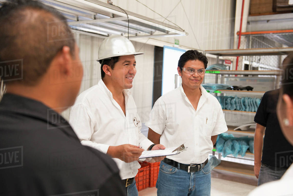 Workers talking in manufacturing plant - Royalty-free Stock Photo ...