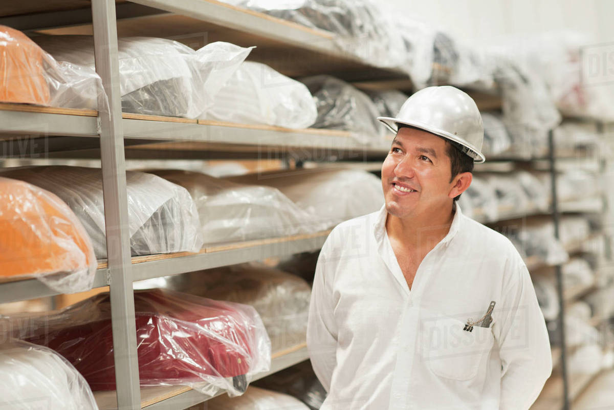 Worker smiling in manufacturing plant - Royalty-free Stock Photo | Dissolve